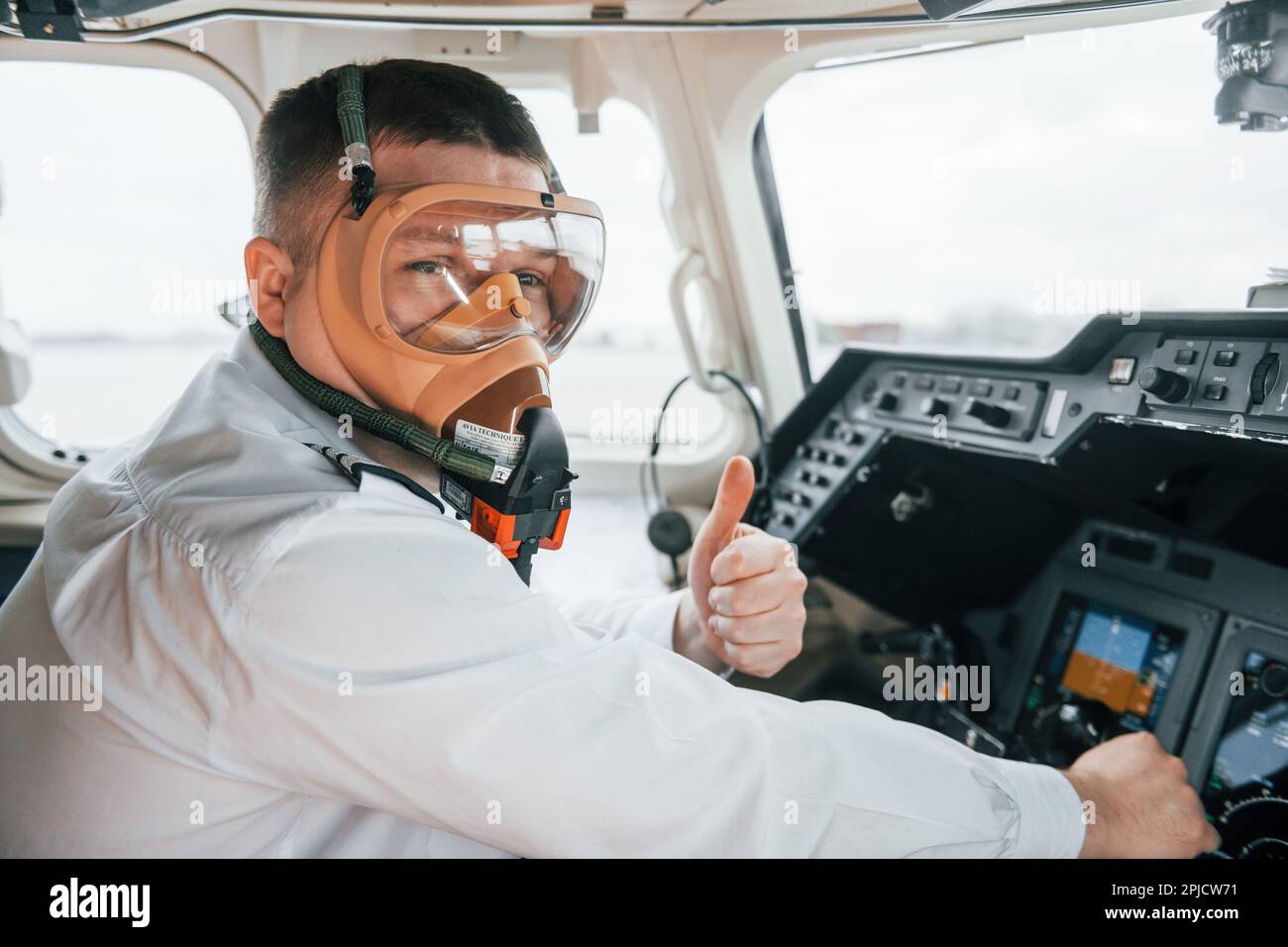 In oxygen mask. Pilot on the work in the passenger airplane. Preparing ...