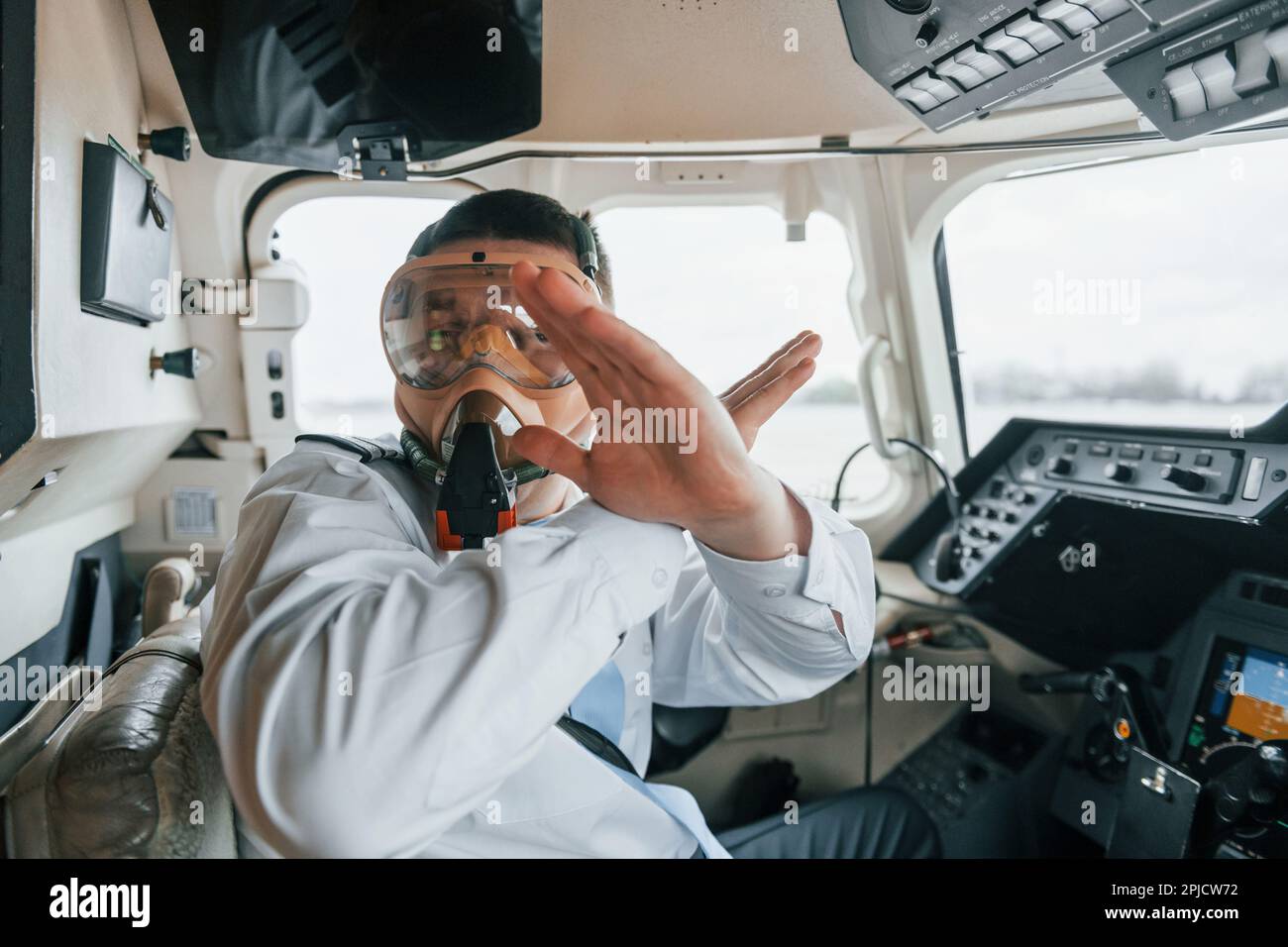 In oxygen mask. Pilot on the work in the passenger airplane. Preparing ...