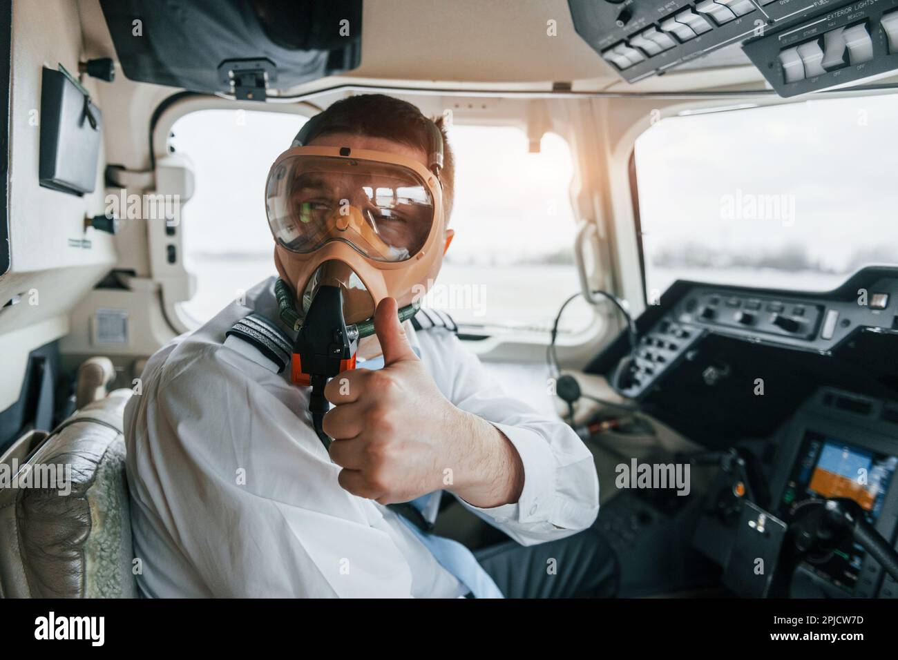 In oxygen mask. Pilot on the work in the passenger airplane. Preparing ...