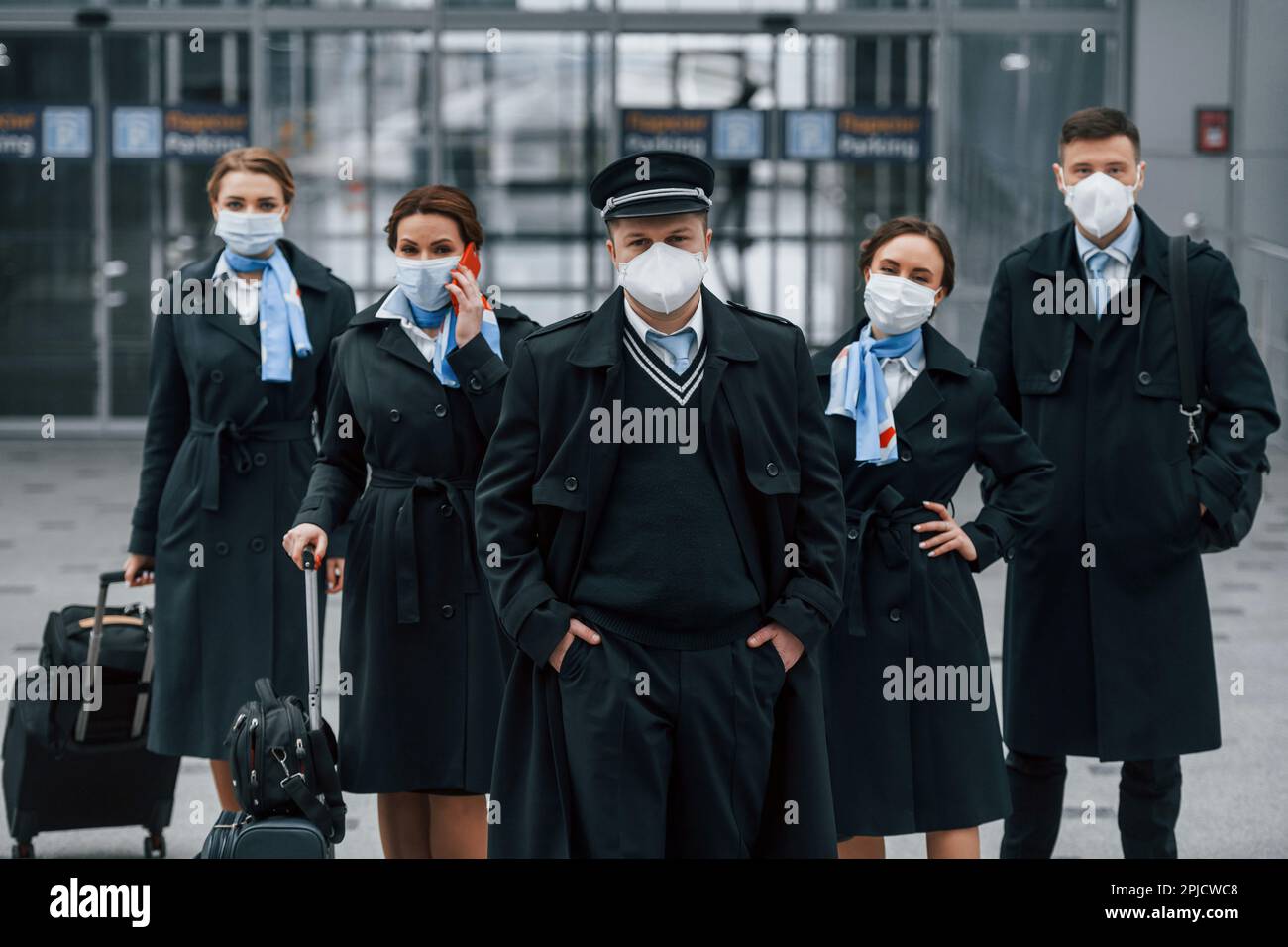 Aircraft crew in work uniform is together outdoors in the airport Stock ...