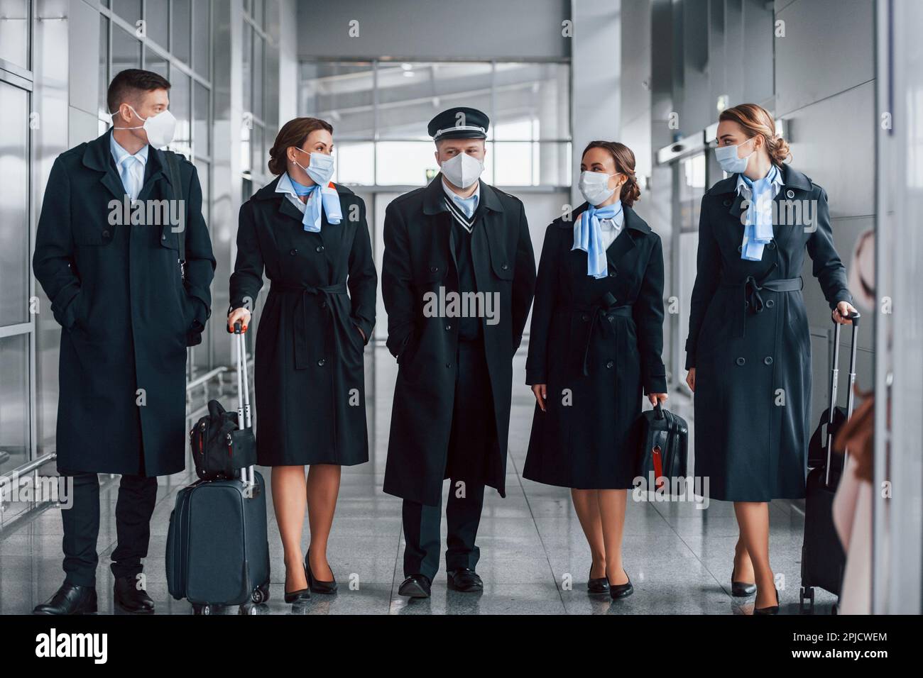 Aircraft crew in work uniform is together outdoors in the airport Stock ...