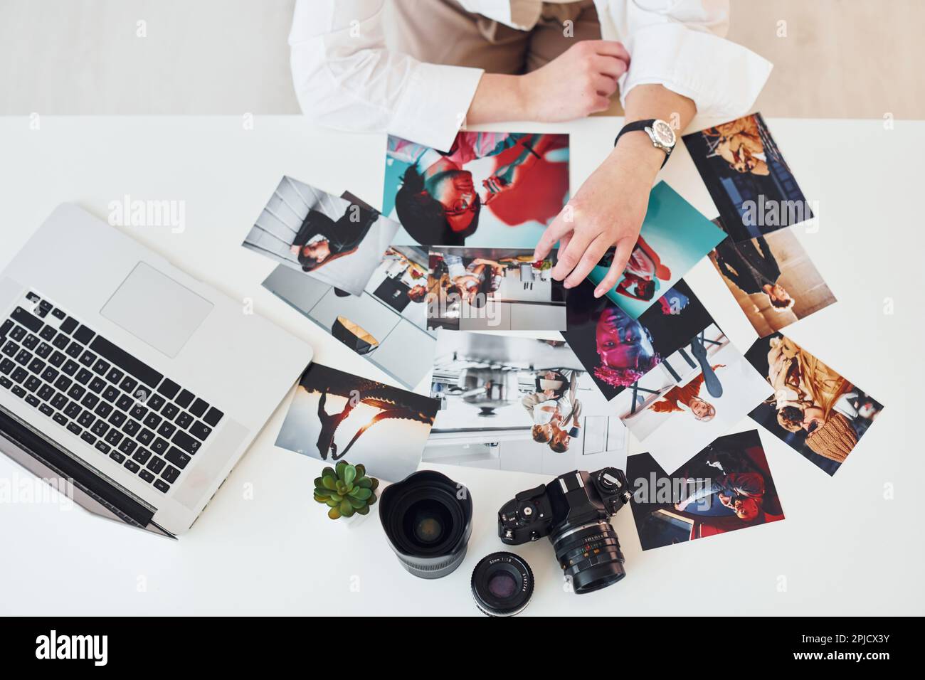 Close up view of table with camera and photos. Female photographer at ...
