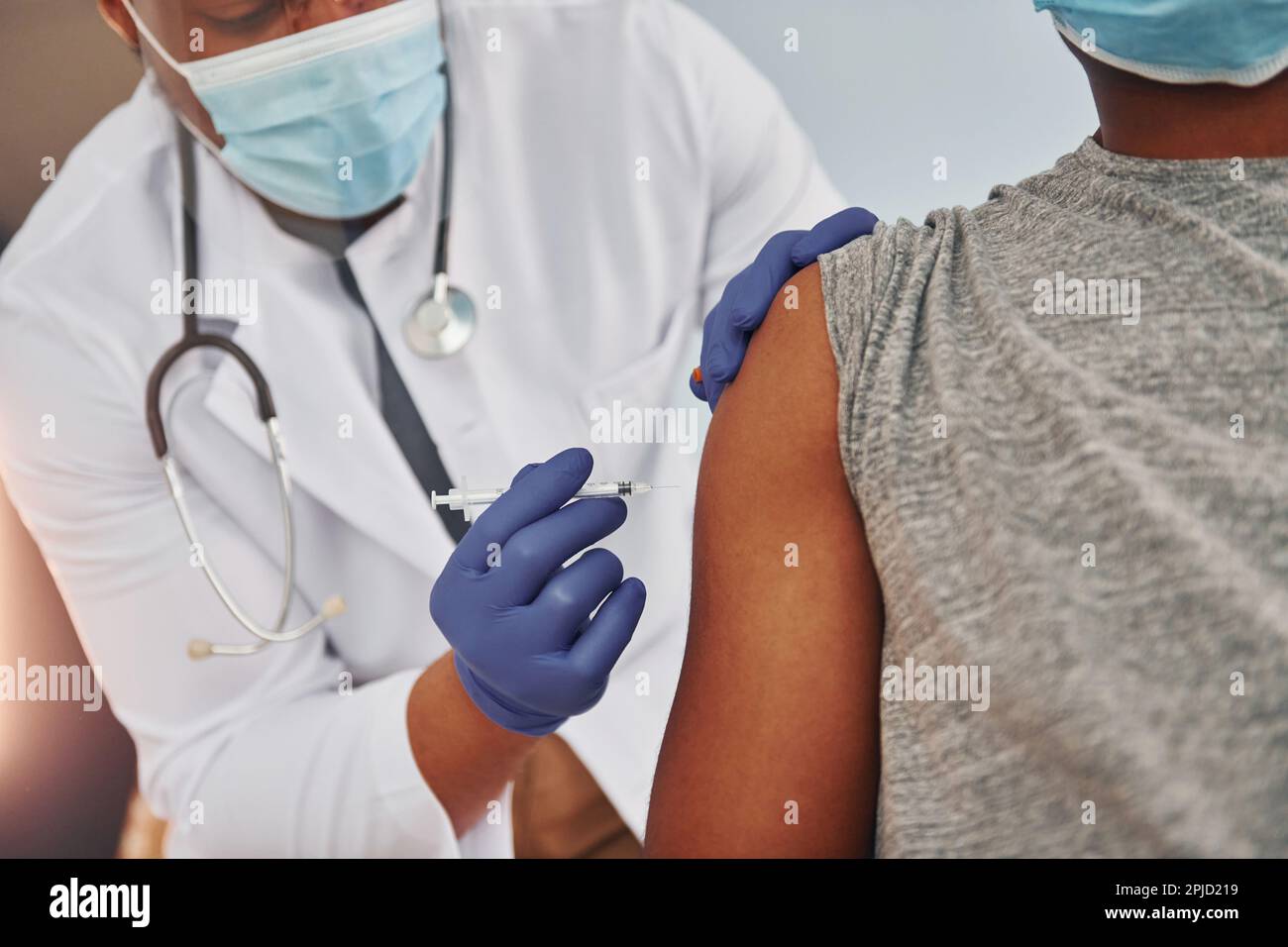 Professional young african american doctor giving injection to patient ...