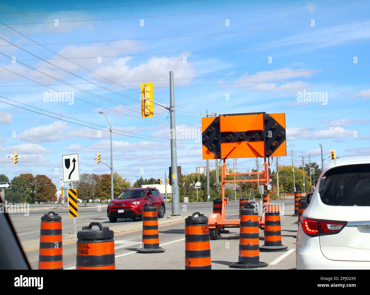Road construction signs and pylons at intersection of busy road Stock ...