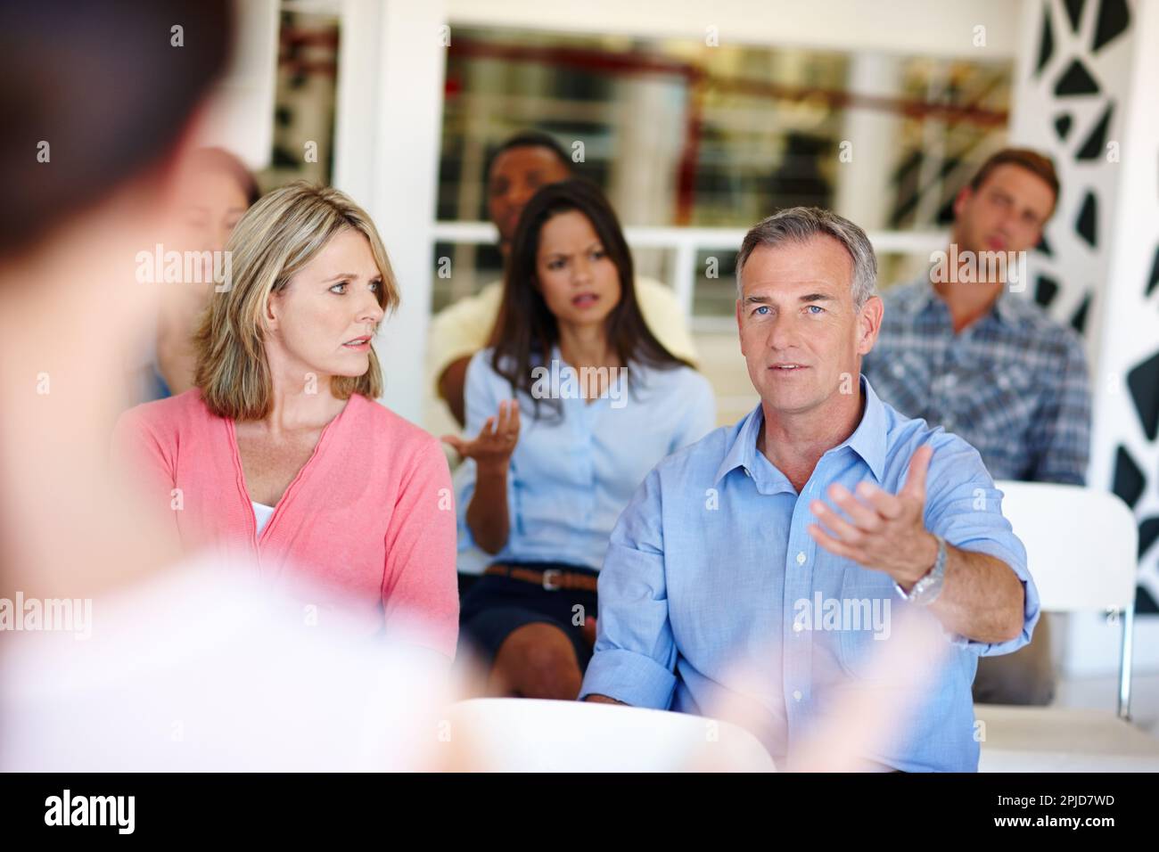 Having his say. man asking a question during a presentation at work ...