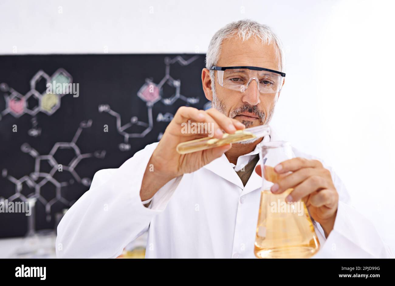 Lets see what happens...a mature male scientist conducting an experiment in his lab Stock Photo ...