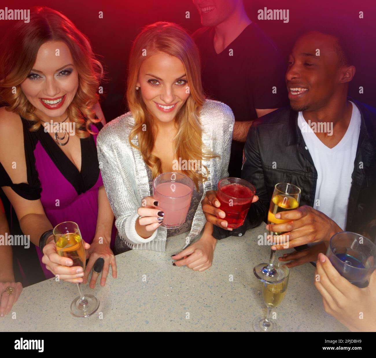 Celebrating good times. A group of friends smiling at the camera while ...