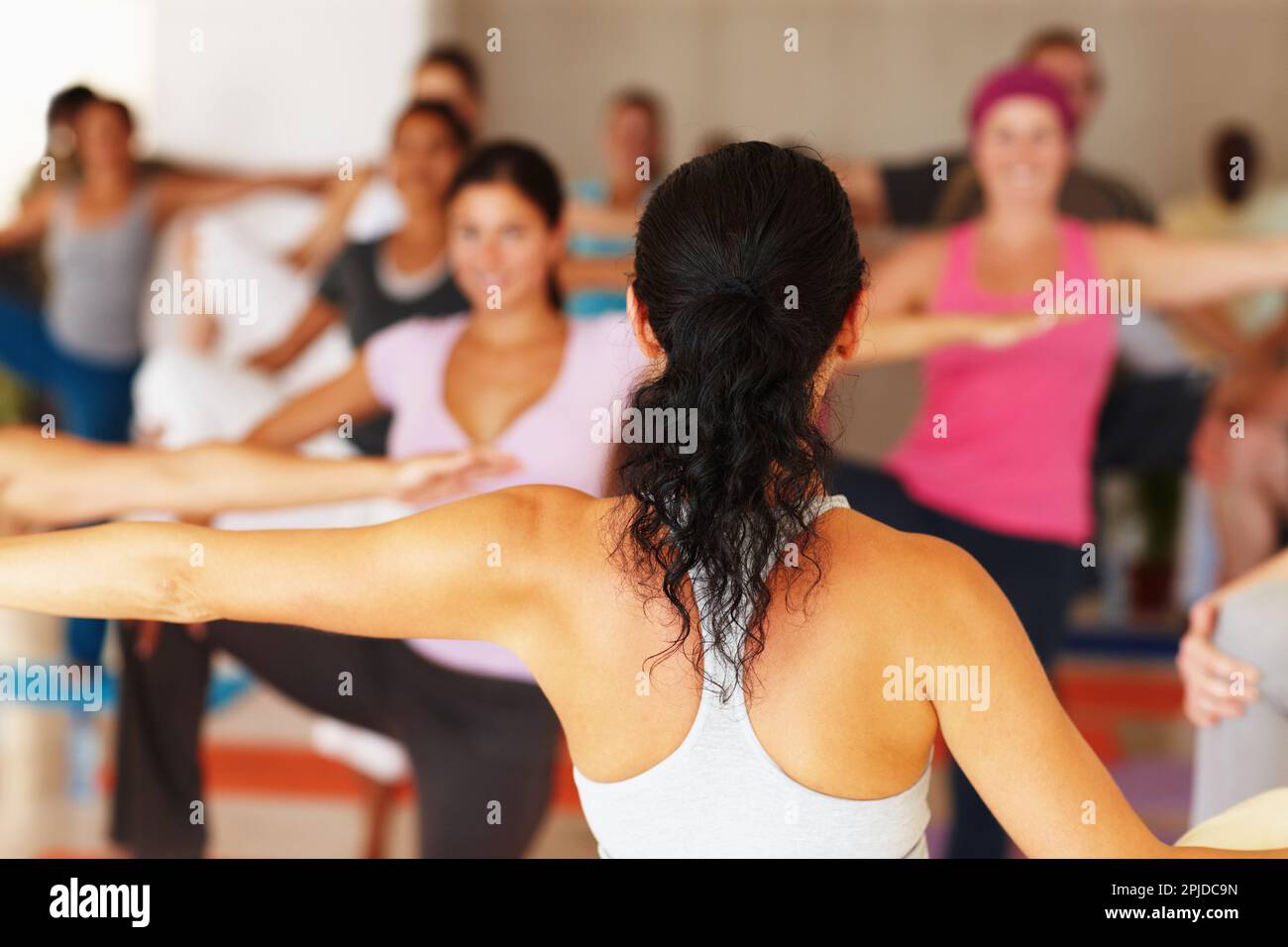 Teaching ways to a healthy mind and body. Rearview shot of a yoga ...