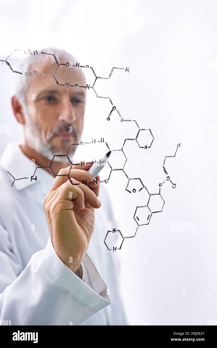 The molecule man. a mature male scientist drawing chemical bonds on a ...