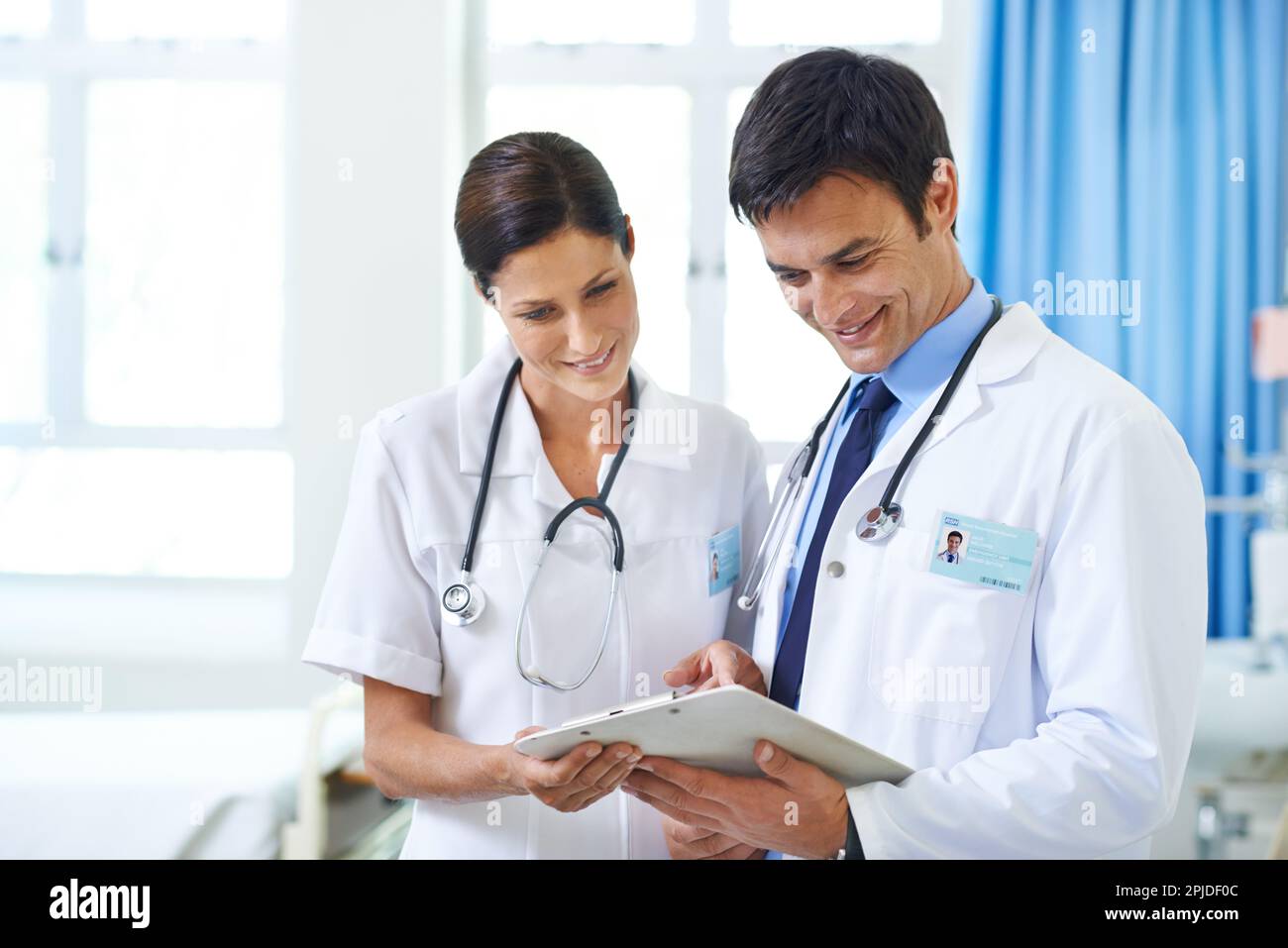 Theyre making progress. a smiling medical team going through a patients ...