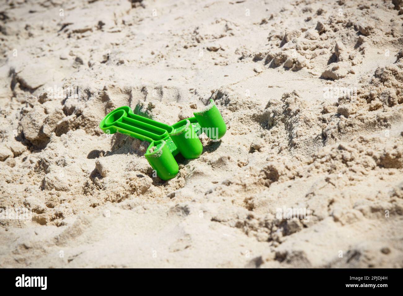 Plastic green rake for relax or playing on sand at beach. Vacation time ...