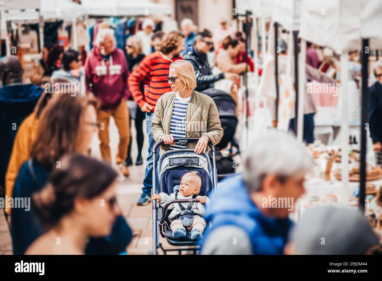 Mother waling and pushing his infant baby boy child in stroller in ...
