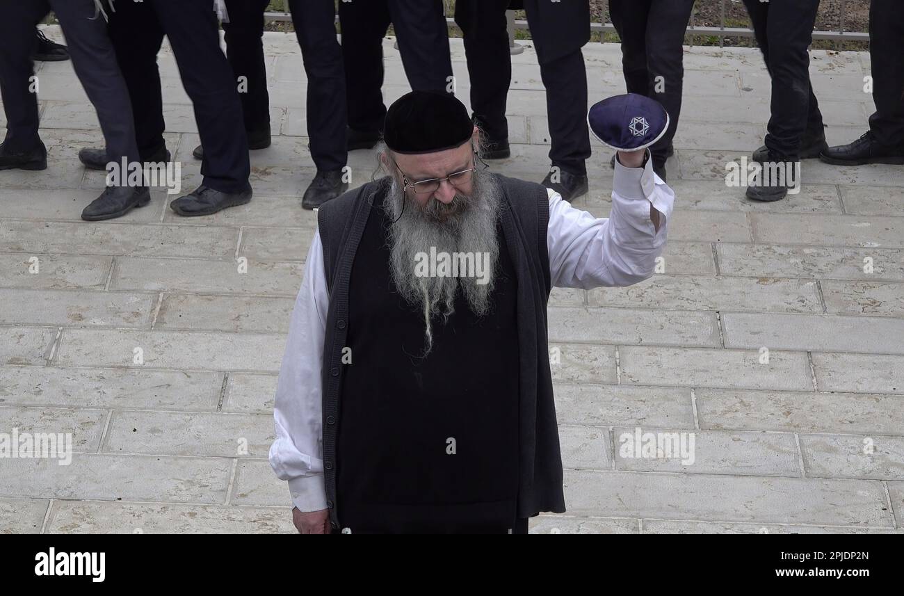 A haredi Jew holds a kippa as other Yeshiva students dance in Jerusalem ...