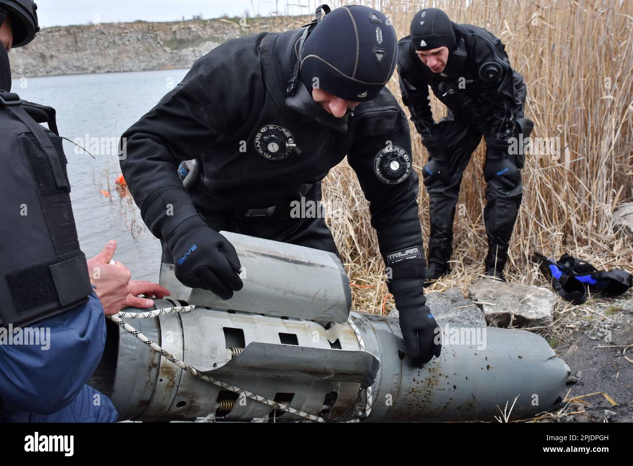 Ukrainian sappers take fragment of a Russian missile out of a lake in ...