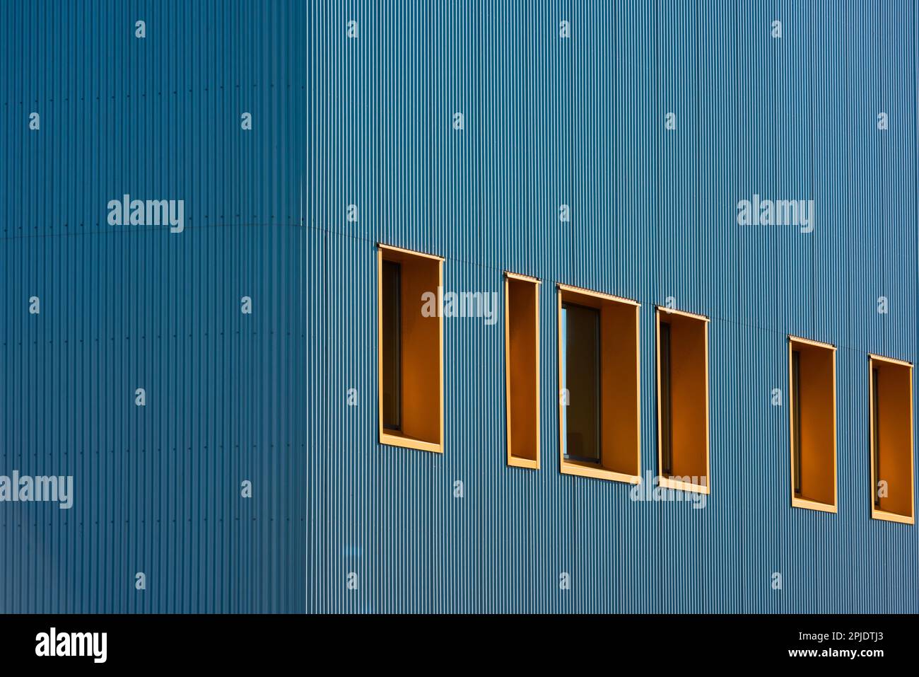 Blue industrial warehouse with yellow window frames Stock Photo - Alamy