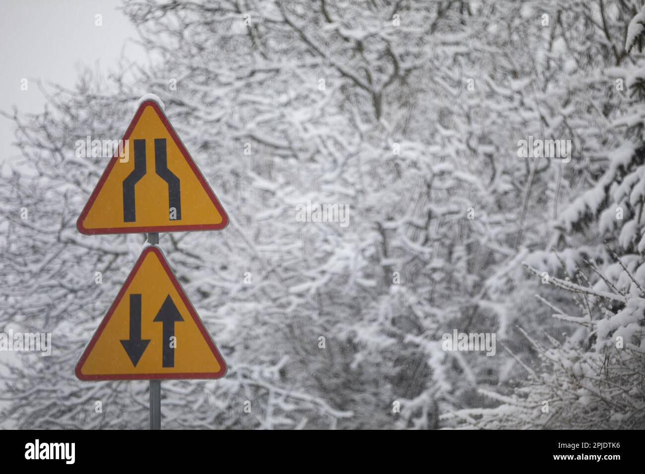Triangle-shaped warning signs against a background of snow-covered ...