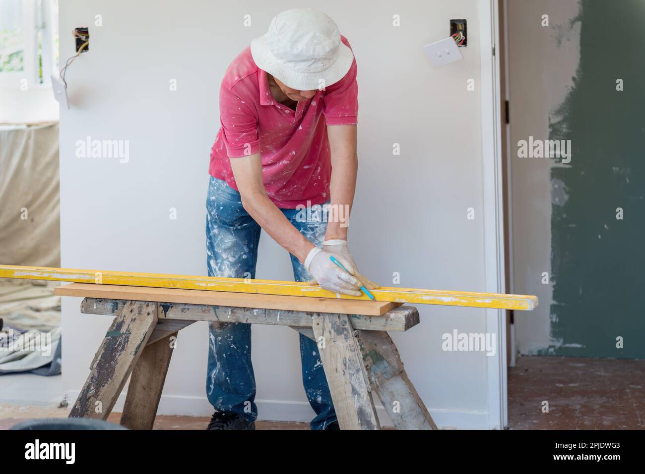 Builder marking the line on wood with pencil. Home renovation project ...