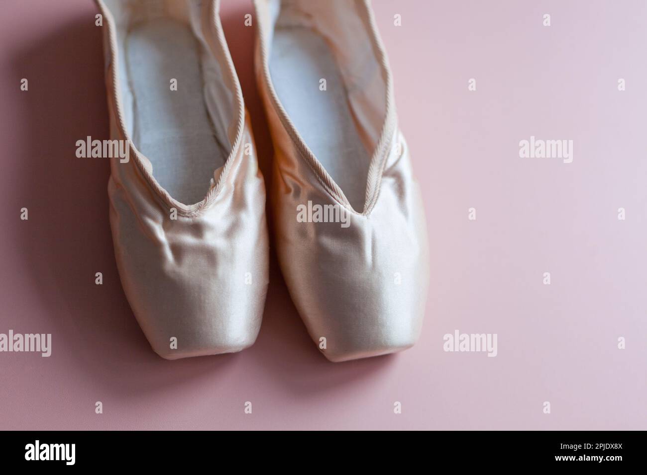 ballet slippers lying on pink background-elegant ballet shoes for dance ...