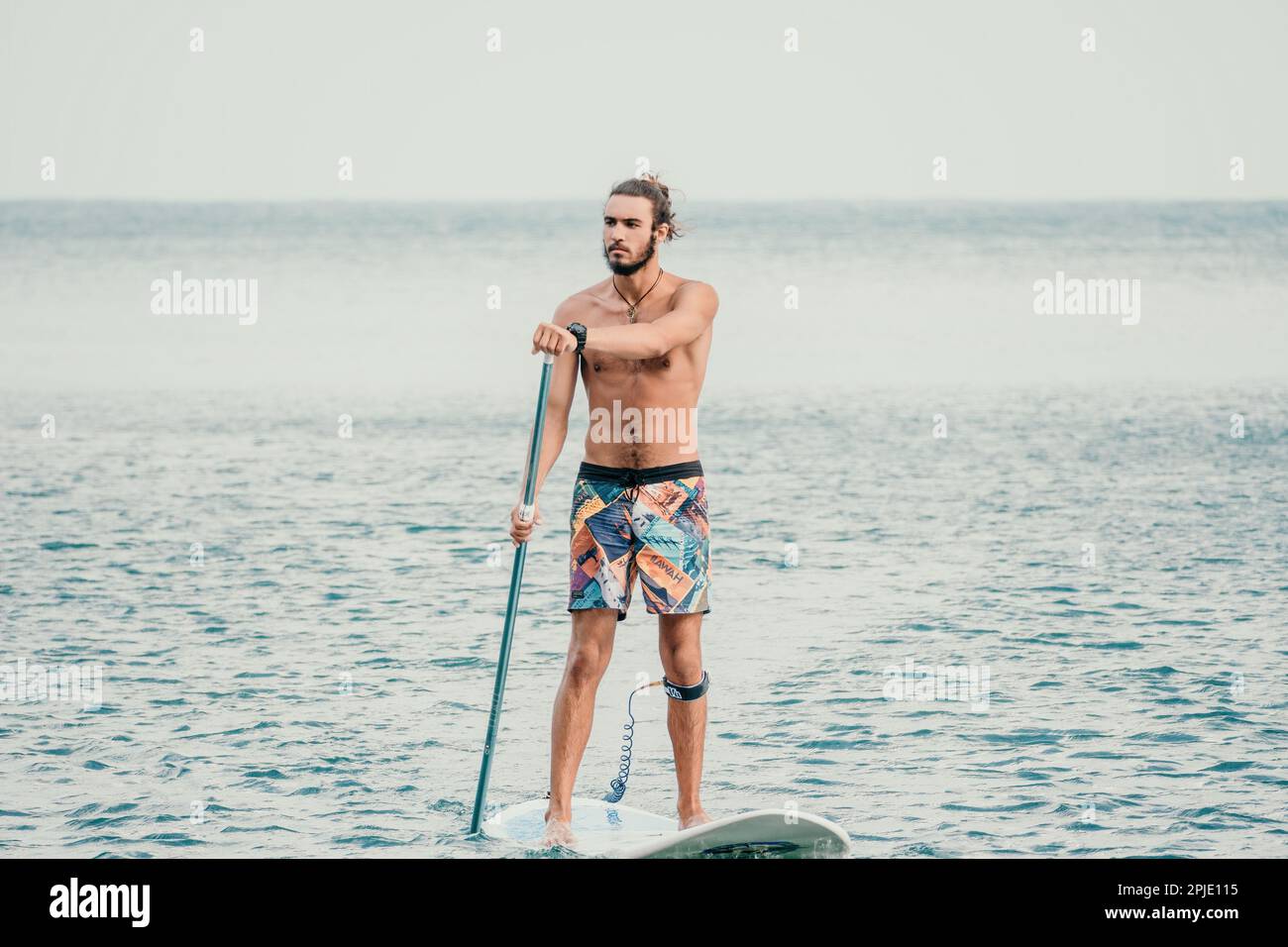 Sea man sup. Asian athlete man swimming in sea and paddleboarding at ...