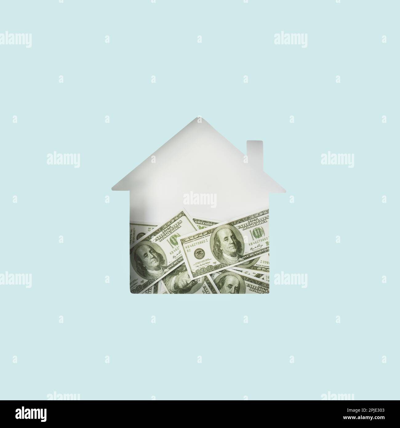 House shape cut out half filled with dollar bills inside. Minimal ...