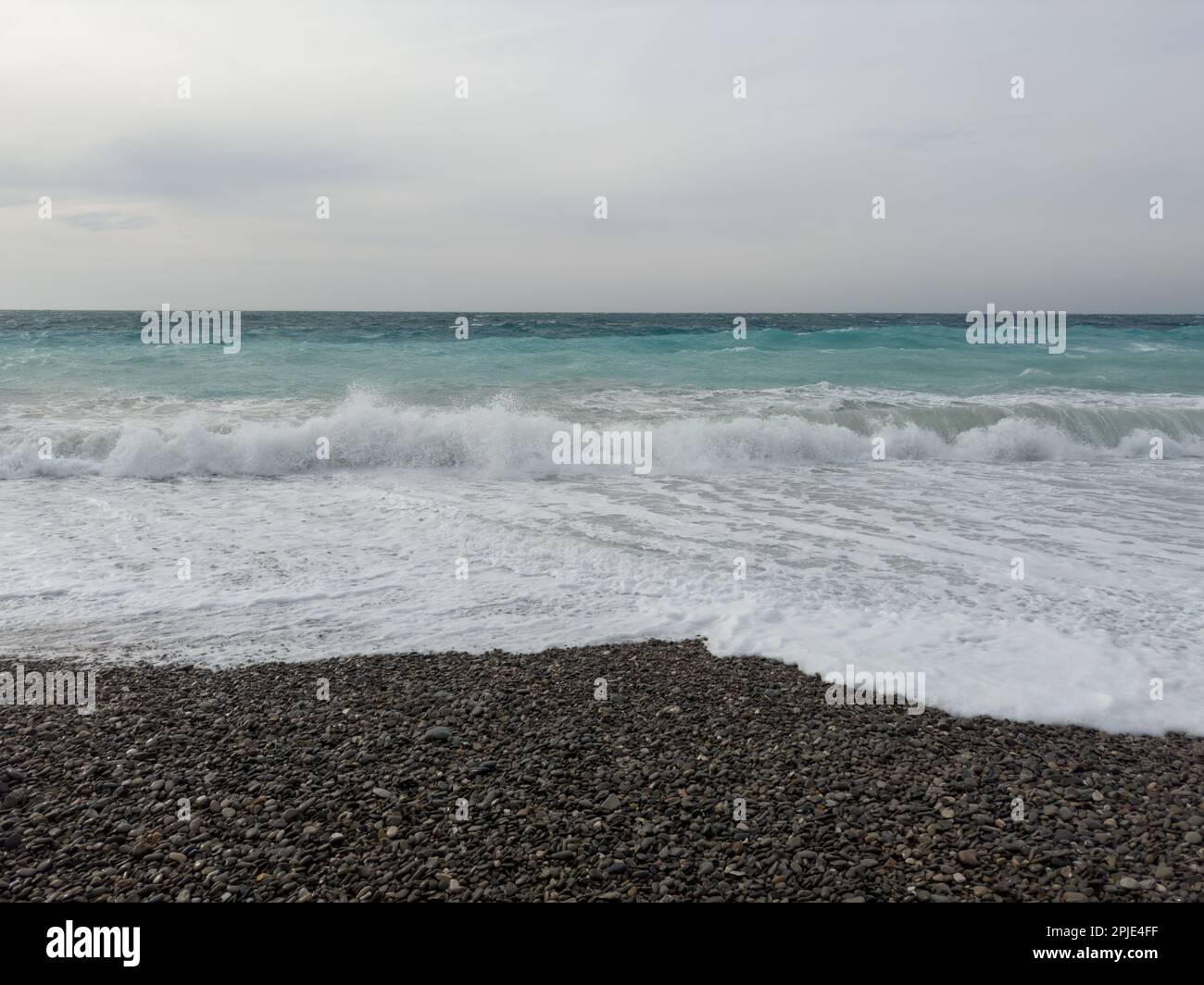 Pebble beach of Nice, France with azure waves of mediterranean sea ...