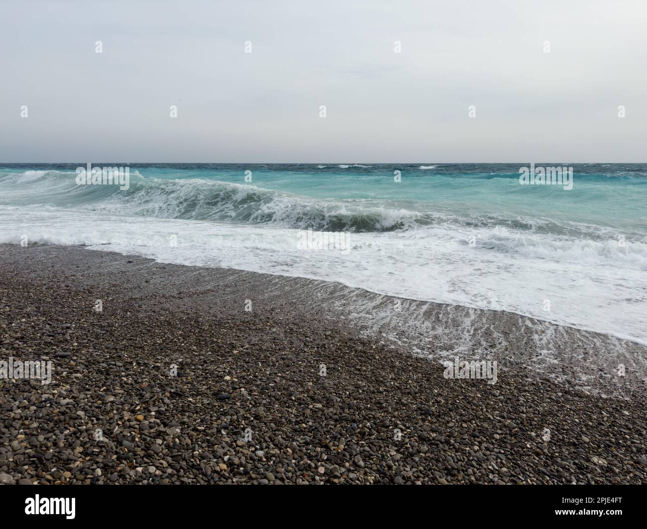 Pebble beach of Nice, France with azure waves of mediterranean sea ...