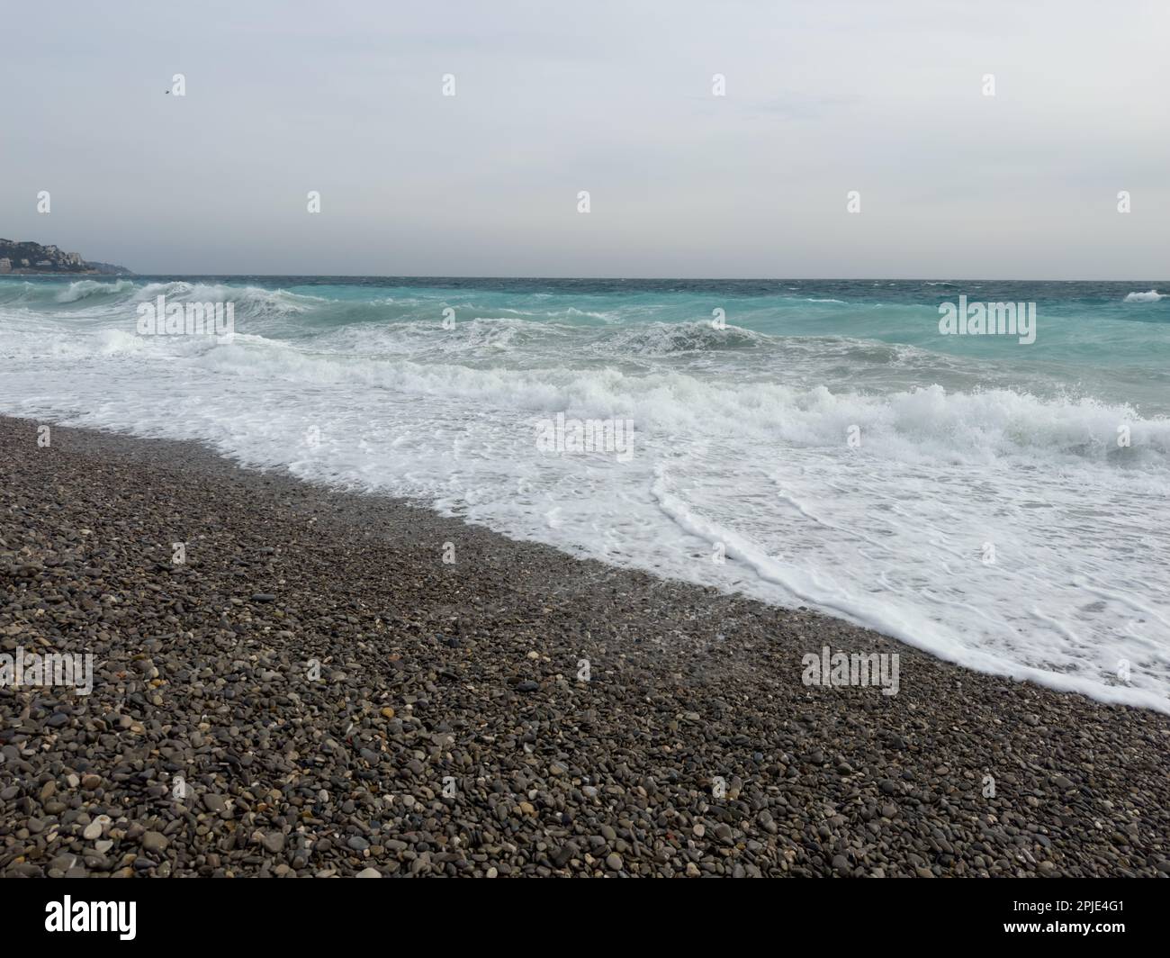 Pebble beach of Nice, France with azure waves of mediterranean sea ...