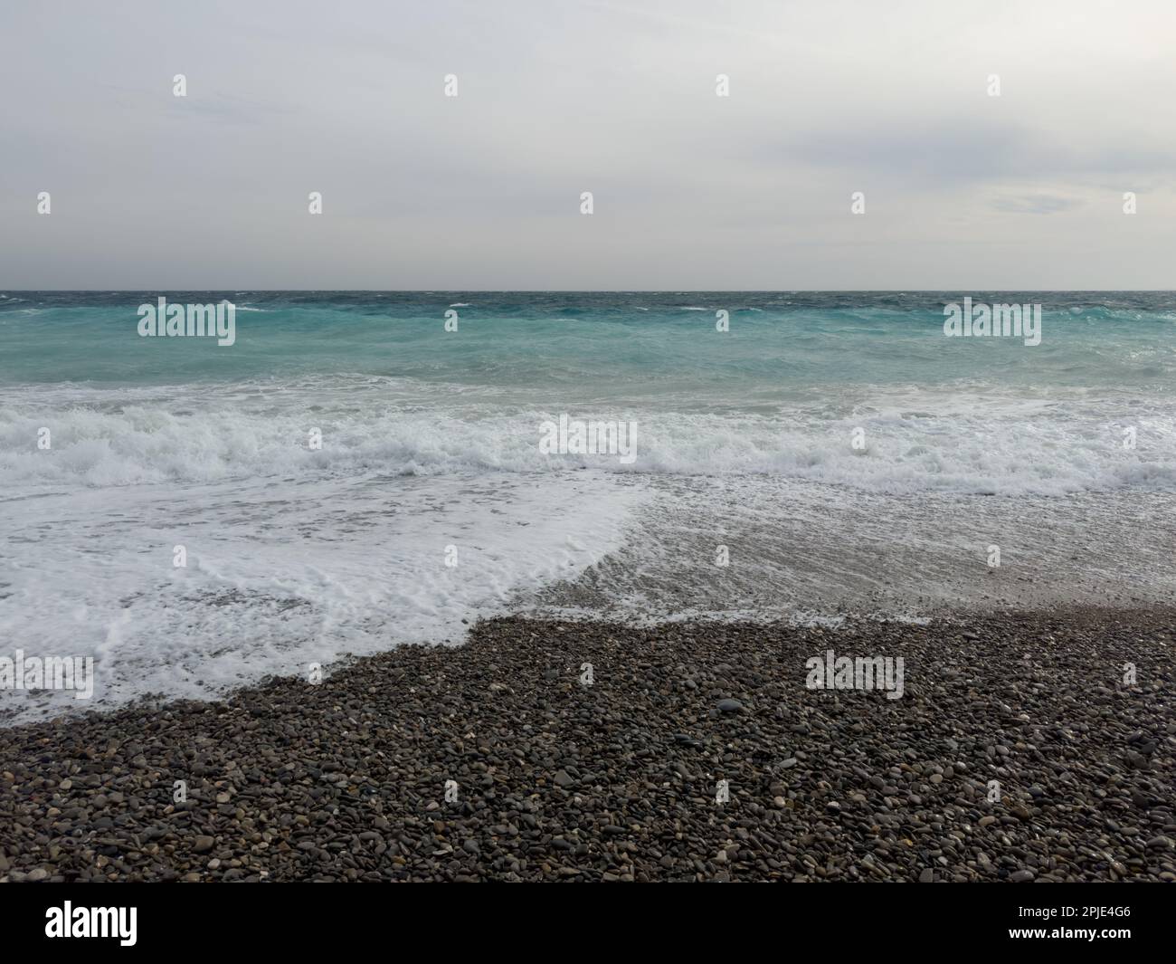 Pebble beach of Nice, France with azure waves of mediterranean sea ...