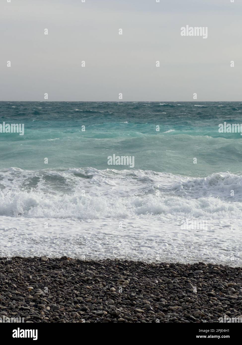 Pebble beach of Nice, France with azure waves of mediterranean sea ...