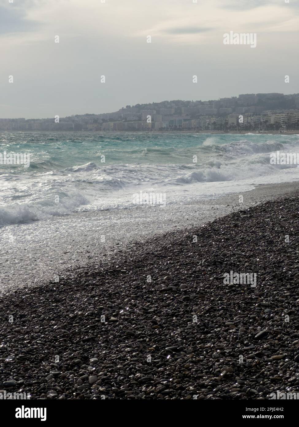 Pebble beach of Nice, France with azure waves of mediterranean sea ...
