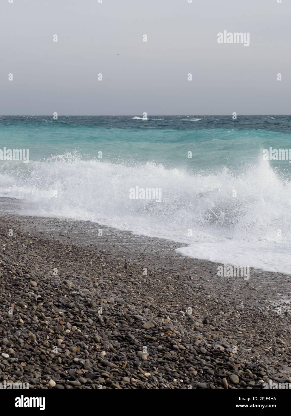 Pebble beach of Nice, France with azure waves of mediterranean sea ...