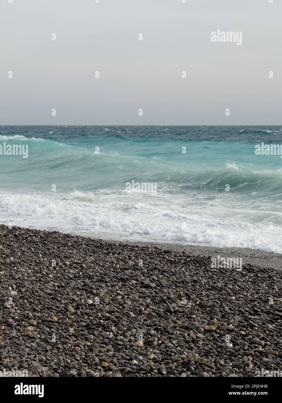 Pebble beach of Nice, France with azure waves of mediterranean sea ...