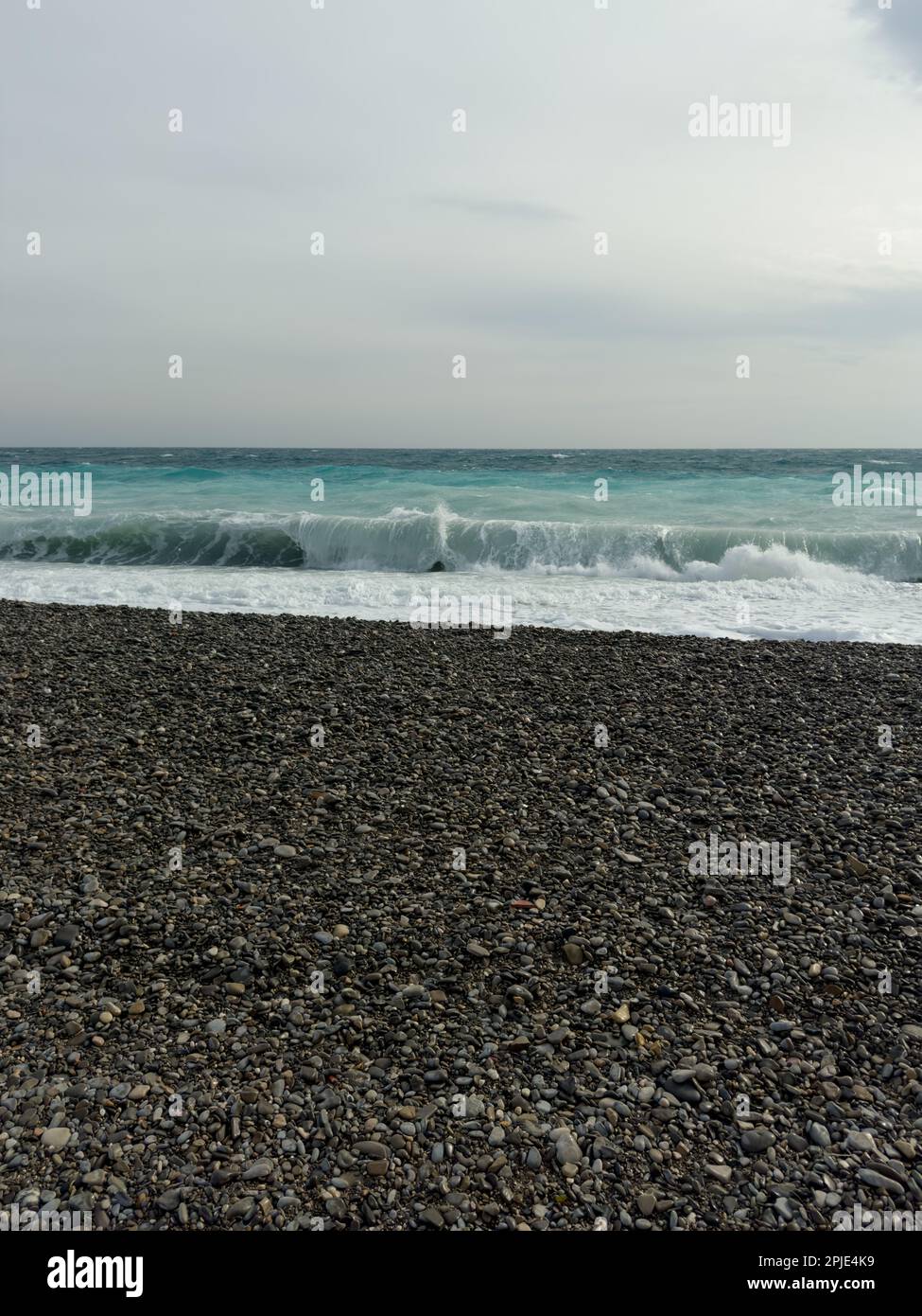 Pebble beach of Nice, France with azure waves of mediterranean sea ...