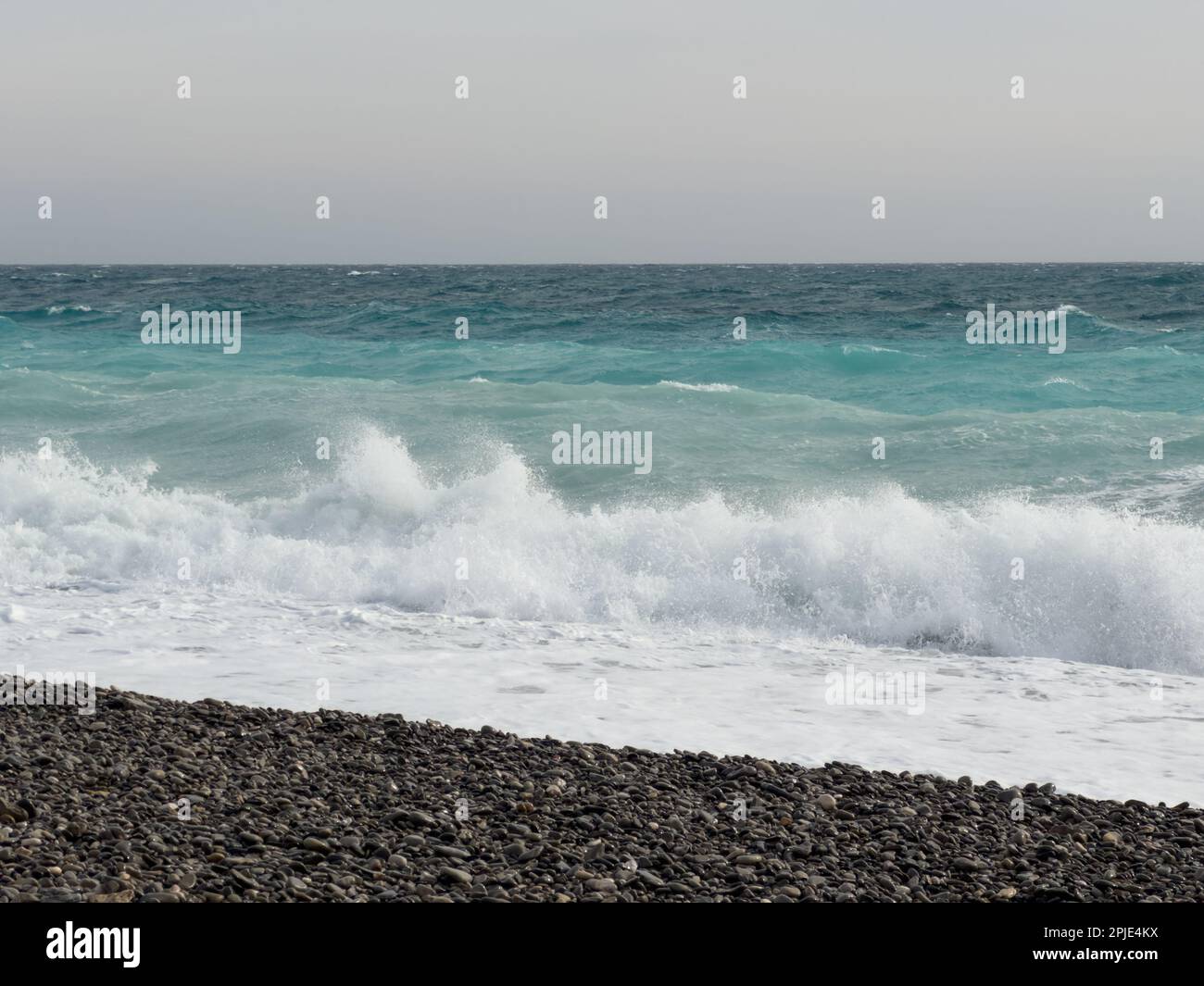 Pebble beach of Nice, France with azure waves of mediterranean sea ...