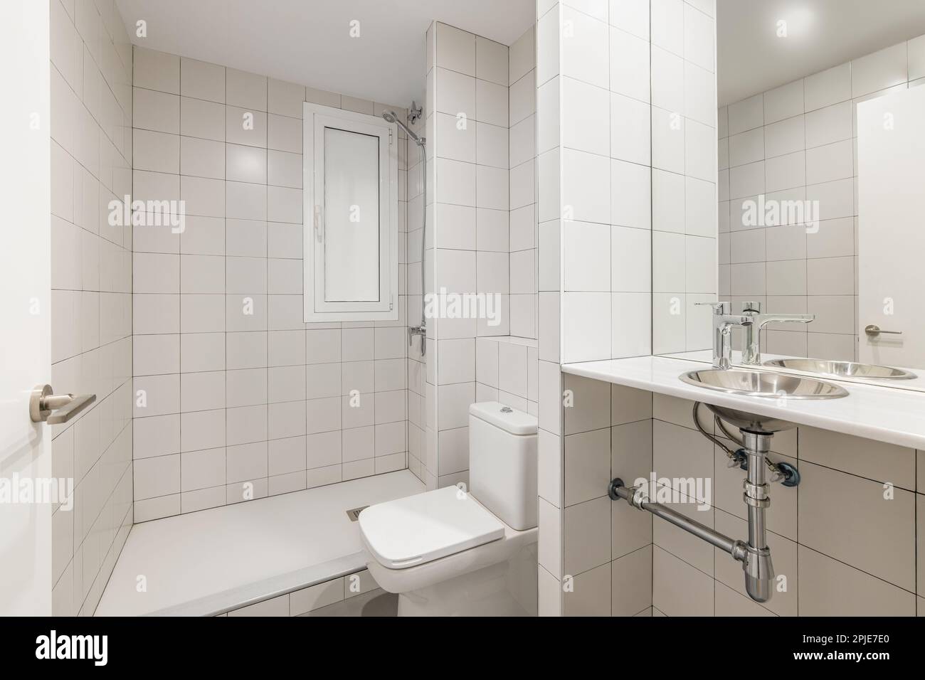 Cozy clean new bathroom with white tiled shower, sink and toilet in a ...