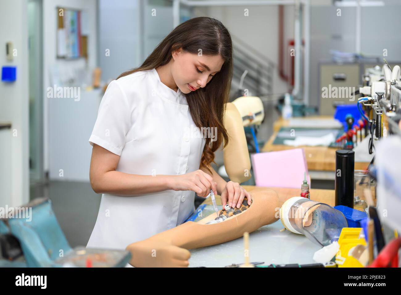 Technician making prototype of prosthetic leg, Artificial metal limb ...