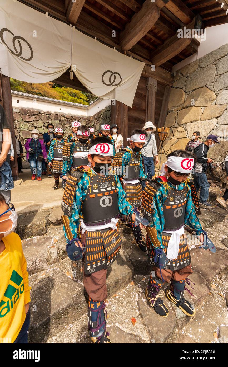 Young Japanese children dressed in ashigaru armour, in two rows walking ...