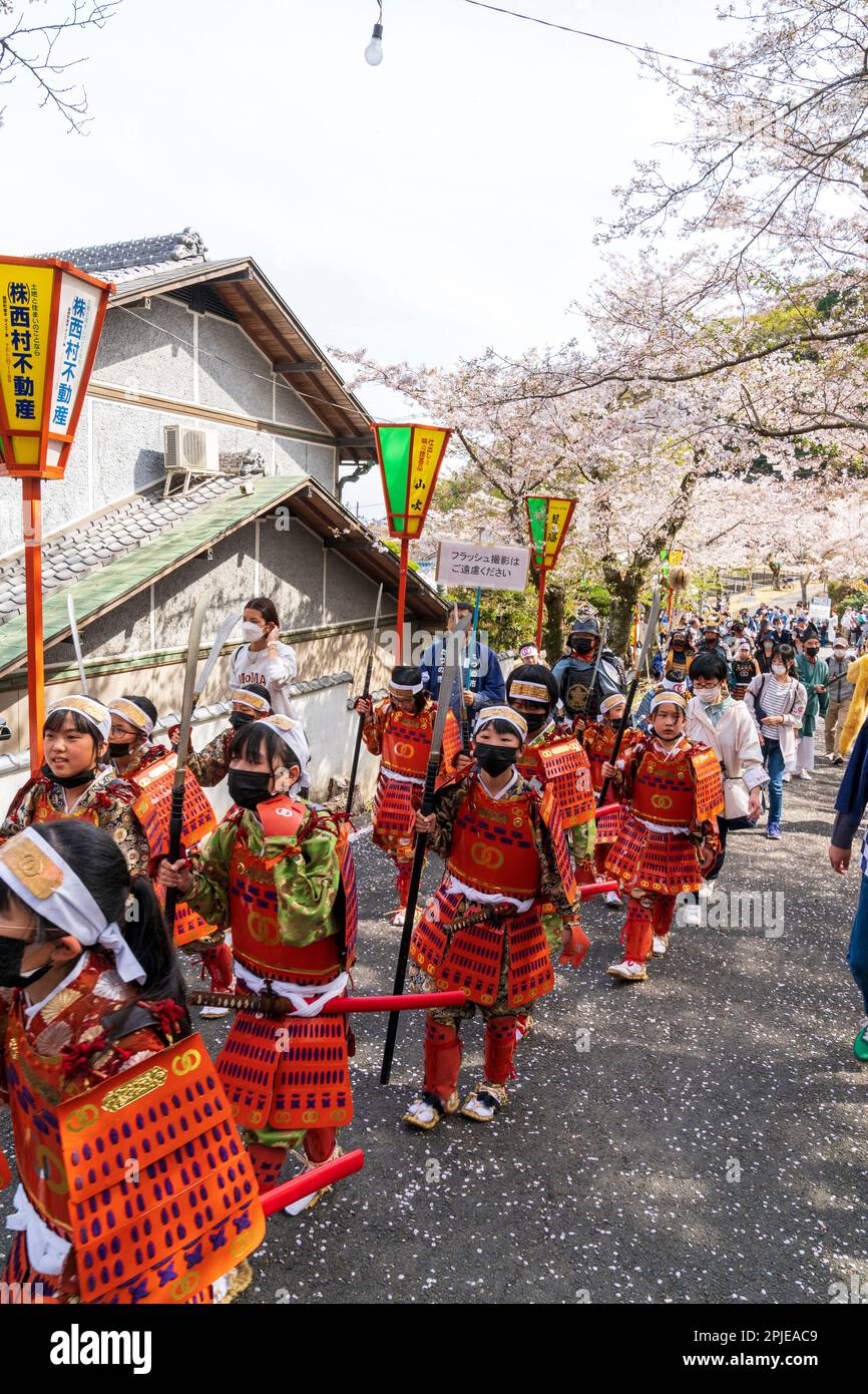 Two rows of young children dressed as samurai warriors in red armour ...