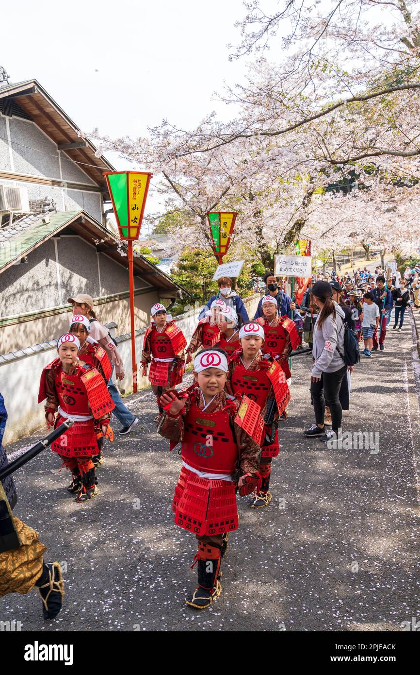 Two rows of young children dressed as samurai warriors in red armour ...