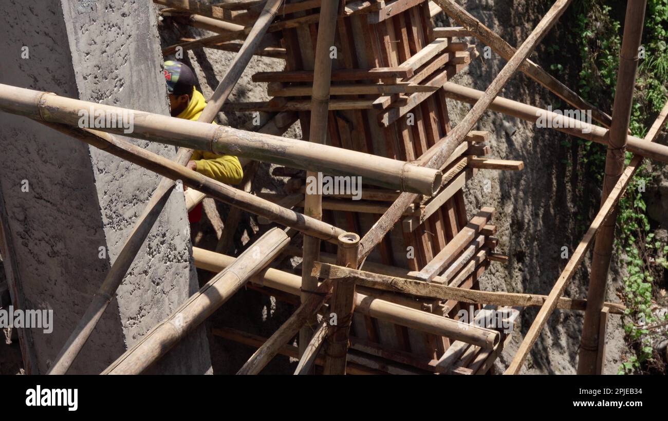 worker-builder of bamboo scaffolding construction site in asia. He ...