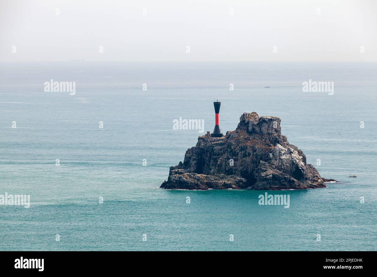 Isolated Danger Mark. Black beacon tower with red stripe is on a small ...