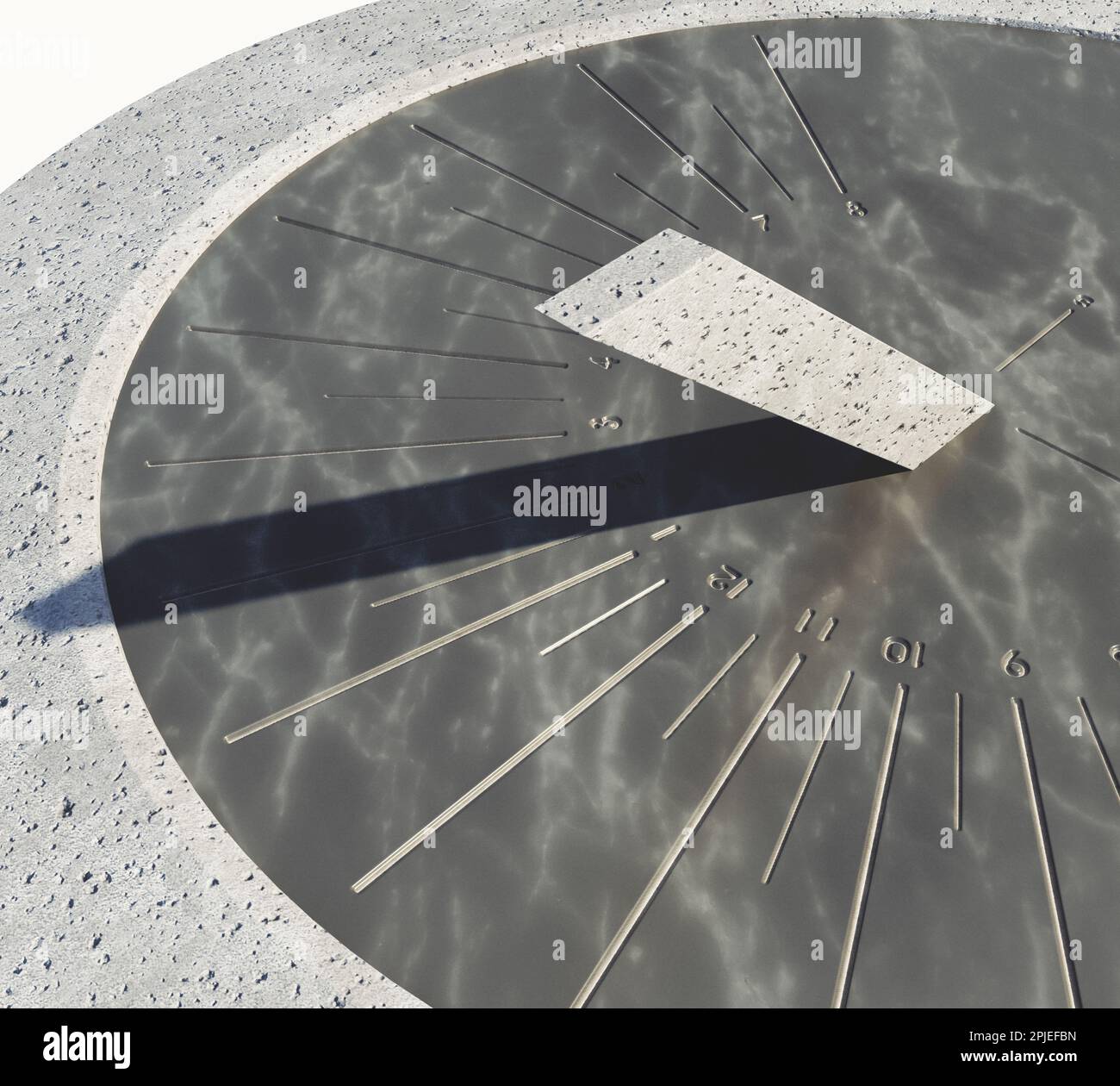 A modern round stone sundial with etched roman numerals standing an a ...