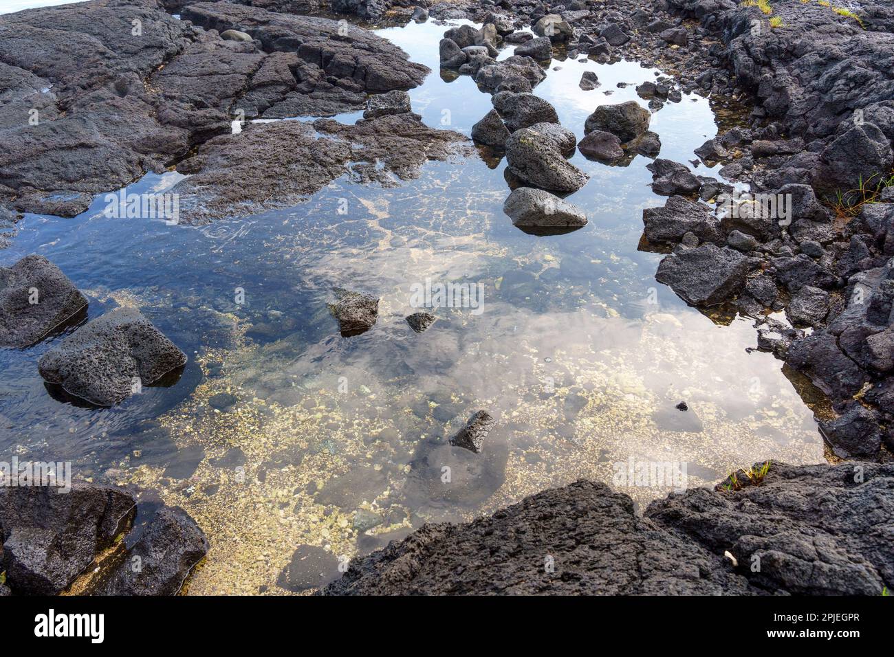 Pool of water nestled between the jagged volcanic rocks, showcasing the ...