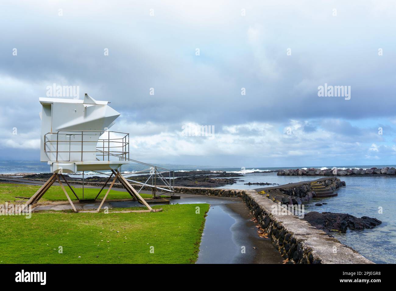 Lifeguard tower stands tall against a dramatic coastal sky, protecting ...
