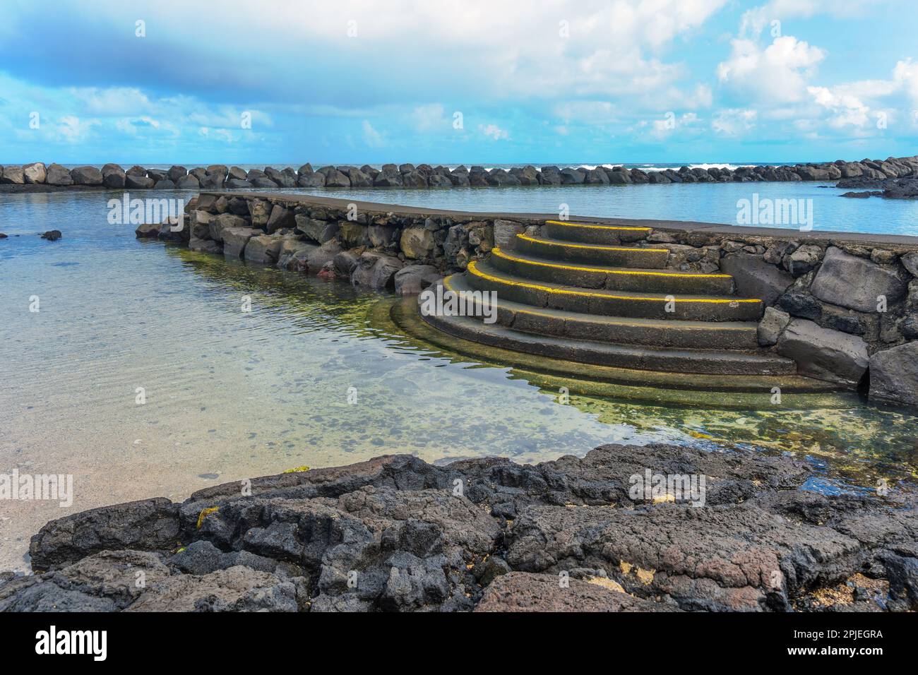 Shallow swimming area separated from the ocean by a wall of massive ...
