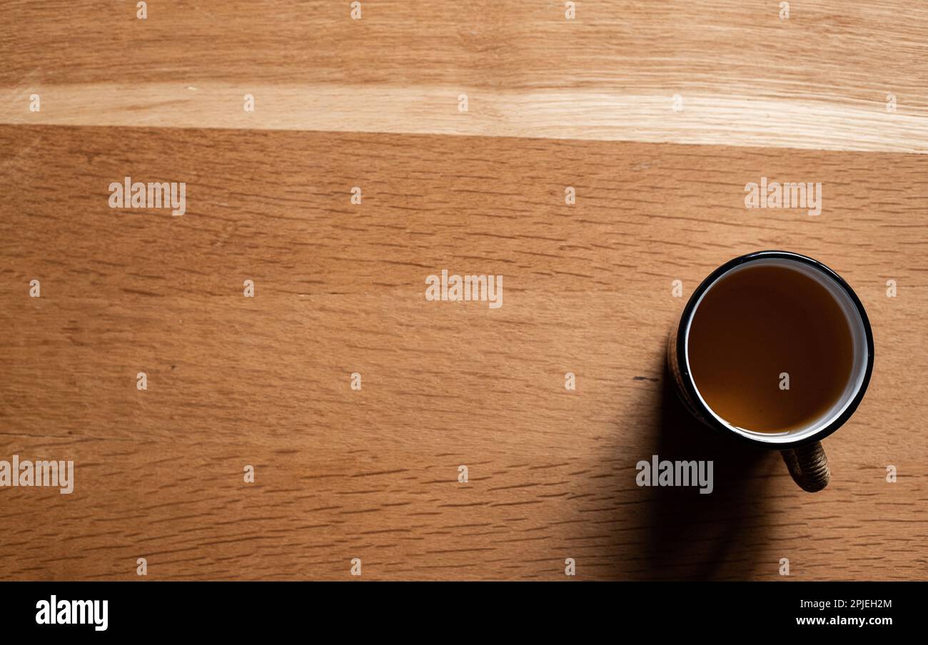 A mug of tea is on the wood background. Tea cup on the wood tabletop ...