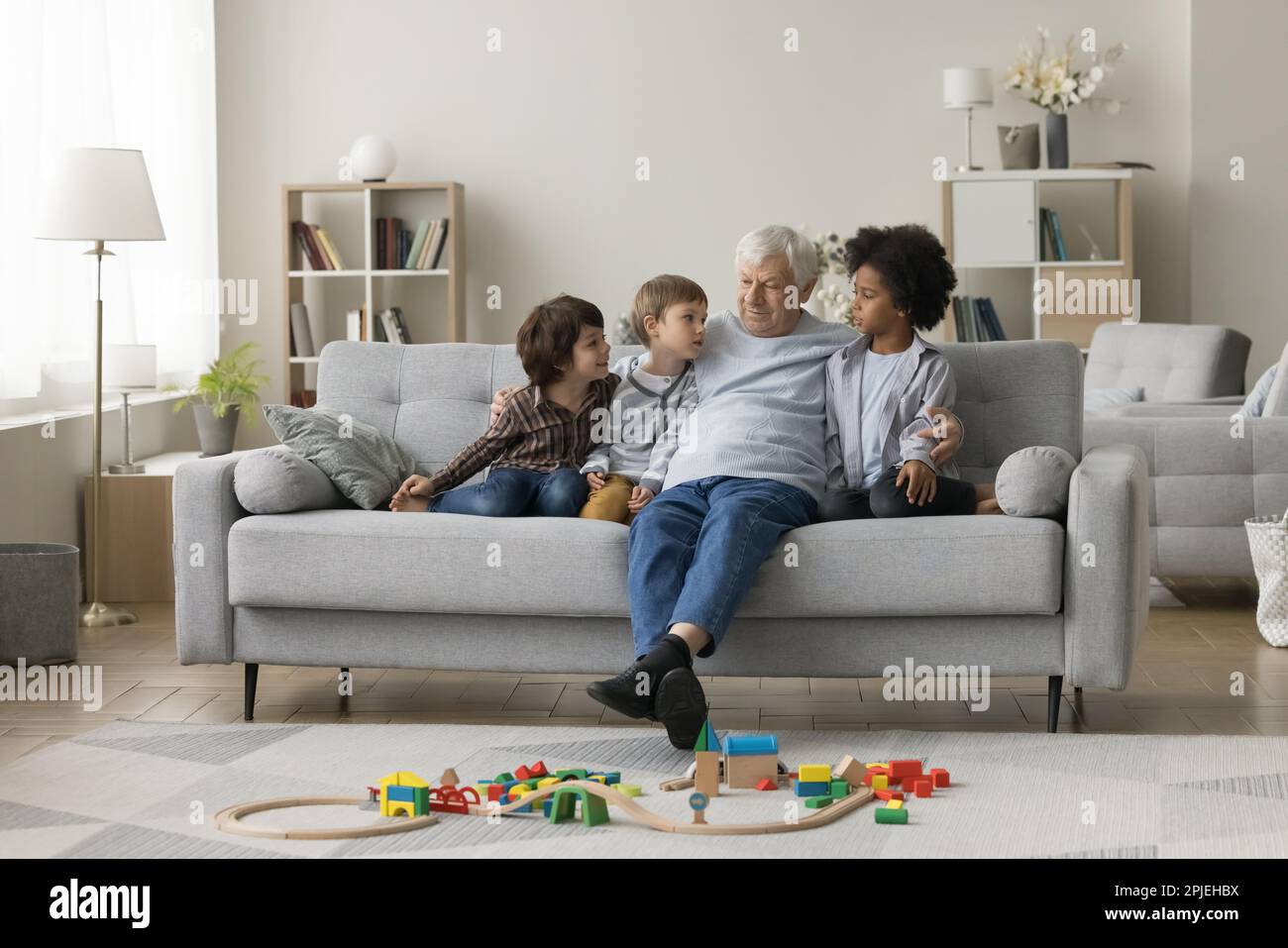 Cute diverse little grandsons visiting old senior grandpa Stock Photo ...