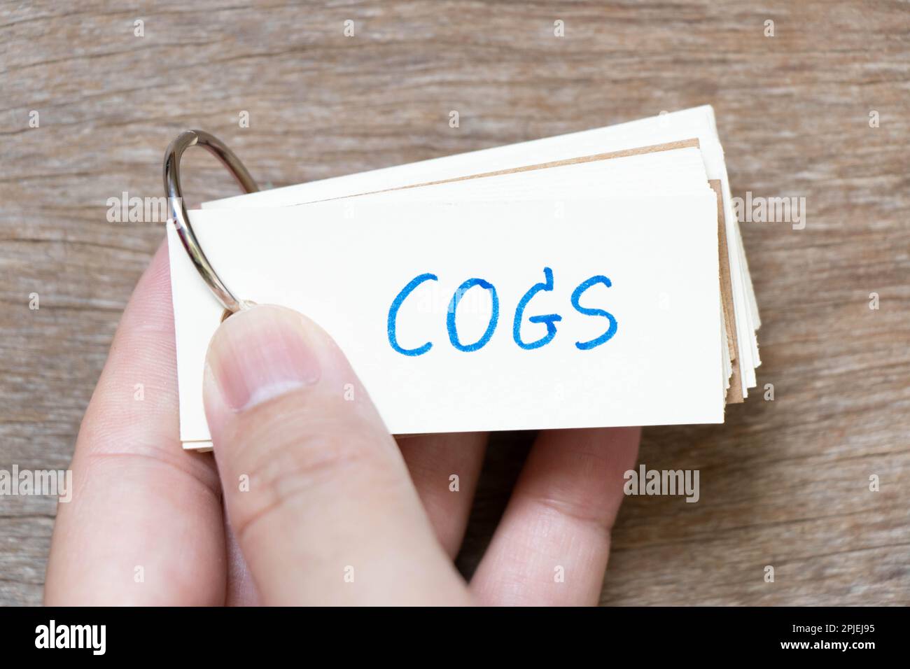 Hand hold flash card with handwriting in word COGS (Abbreviation of ...
