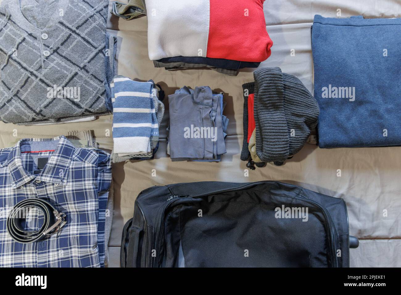 Clothes and suitcase on the bed prepared for a trip, top view Stock ...