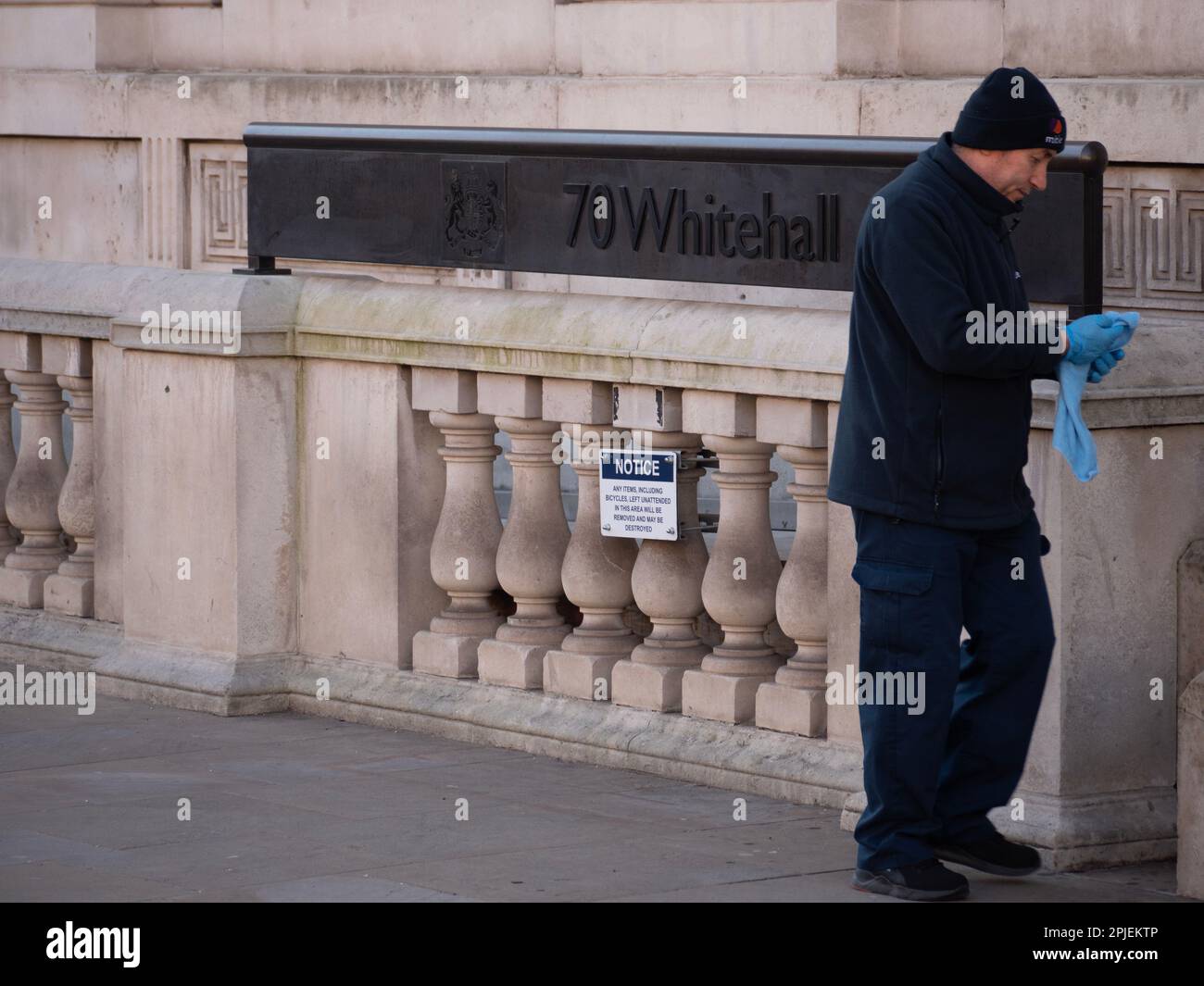 Cleaner working for Mitie polishing sign at The Cabinet office 70 ...